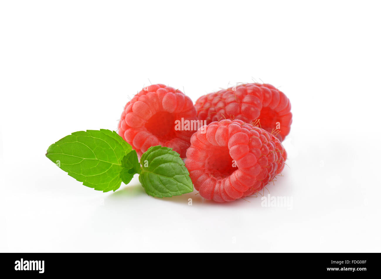 three raspberries with leaves on white background Stock Photo - Alamy