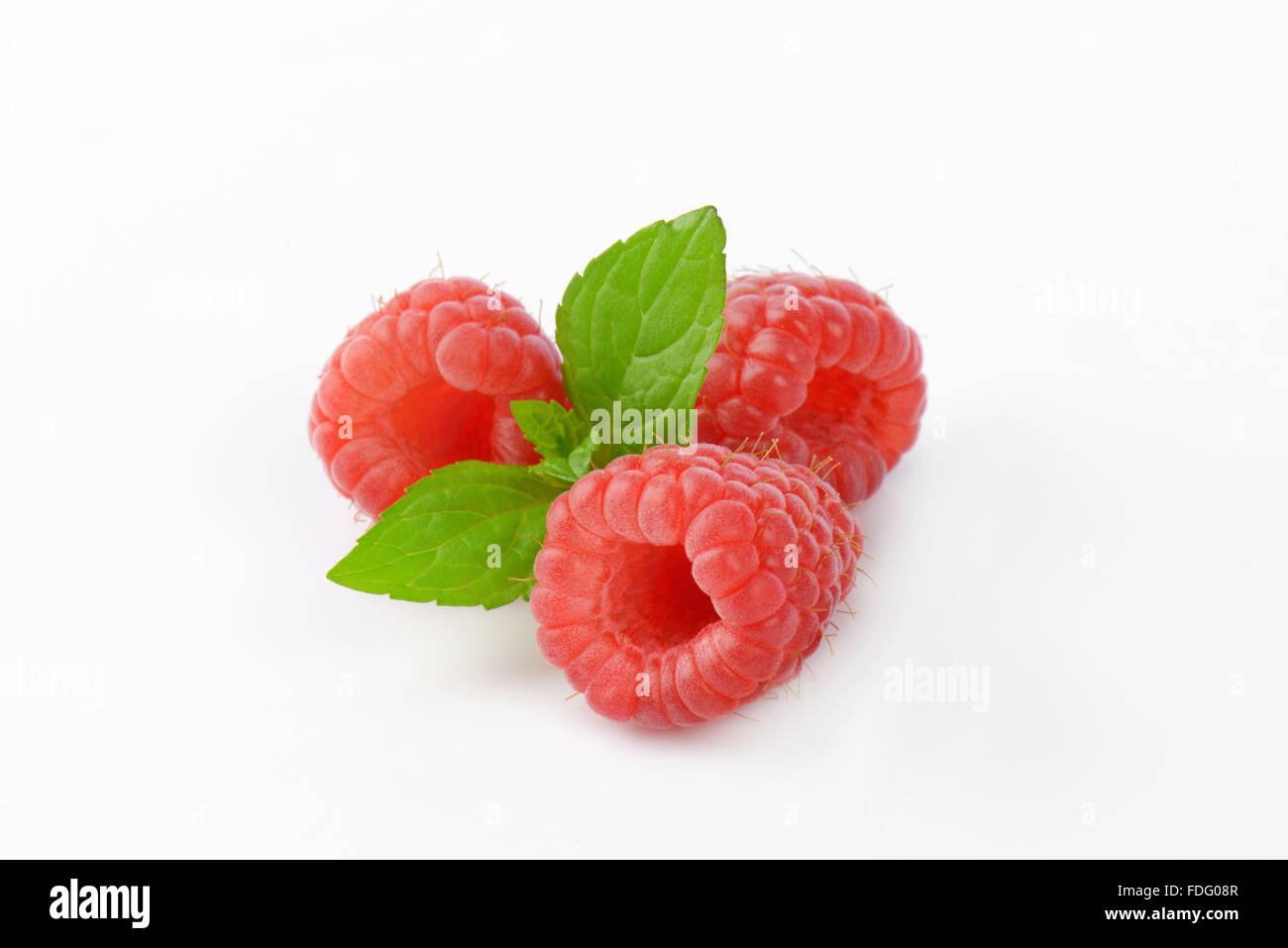 three raspberries with leaves on white background Stock Photo - Alamy