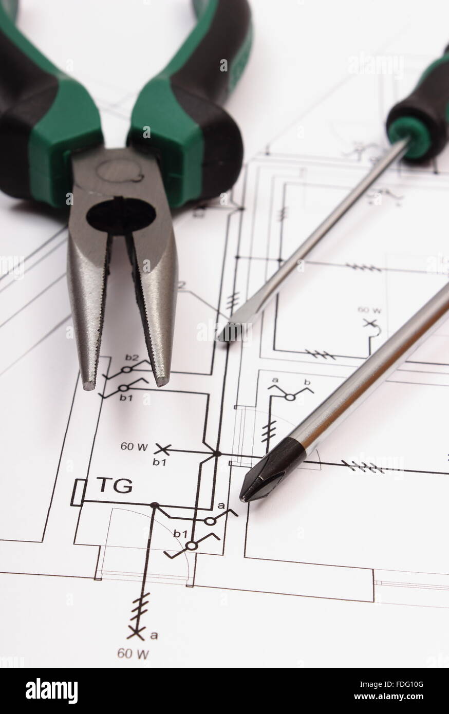 Metal pliers and screwdriver on electrical construction drawing of ...