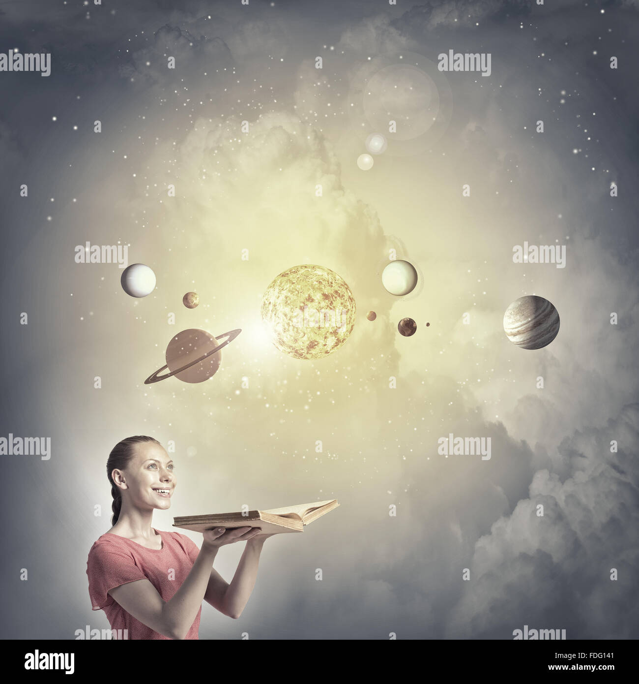 Young woman with book exploring planets of sun system Stock Photo - Alamy