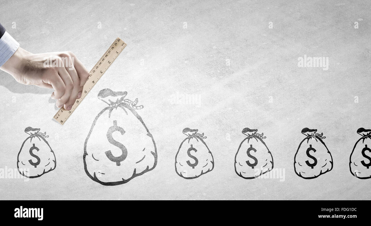 Close up of human hand measuring money bag with ruler Stock Photo - Alamy