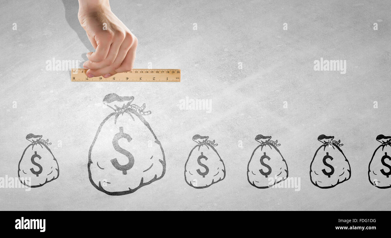 Close up of human hand measuring money bag with ruler Stock Photo - Alamy