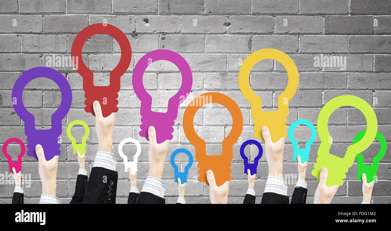 Many human hands holding light bulb signs Stock Photo - Alamy