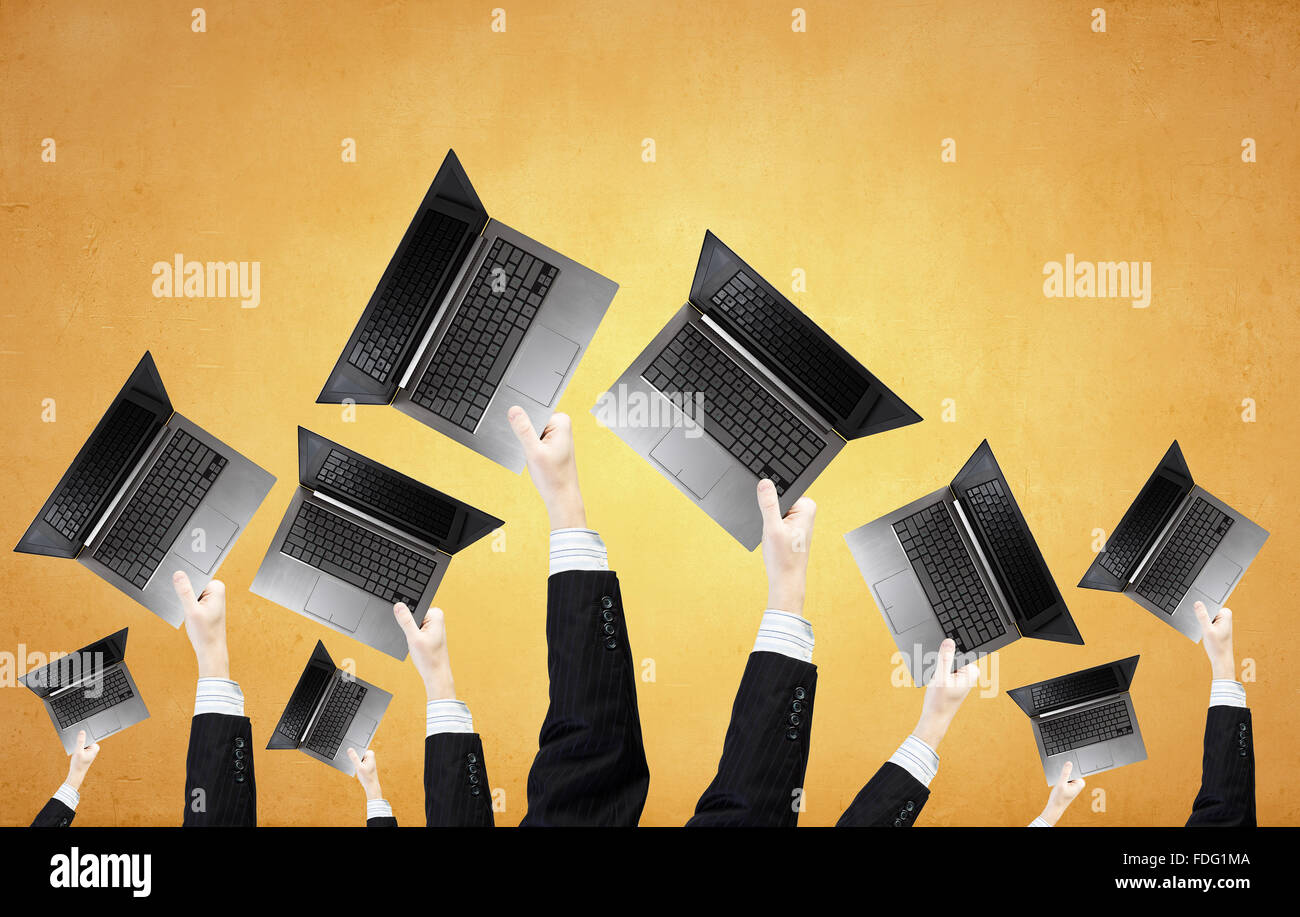Many business people holding in hands laptops Stock Photo - Alamy