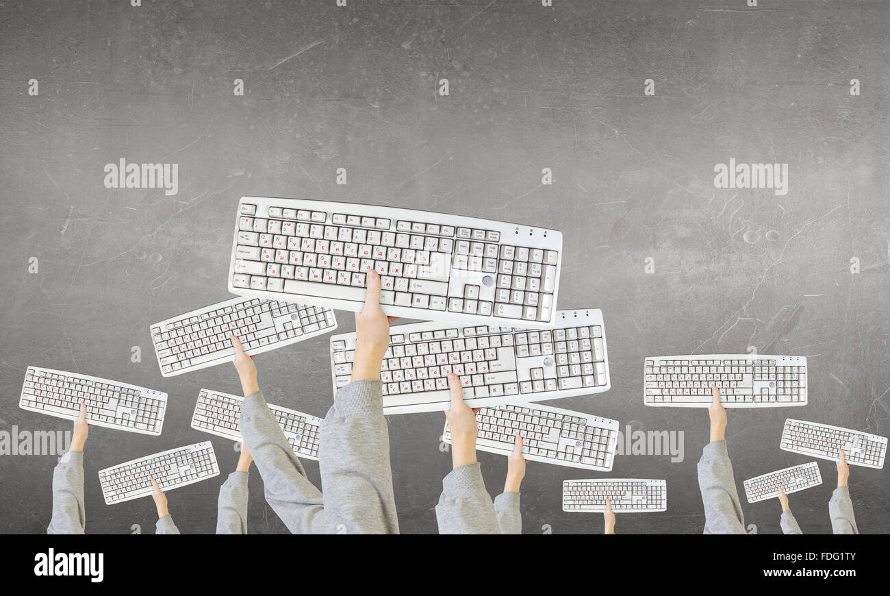 Group of business people holding keyboards in raised hands Stock Photo ...