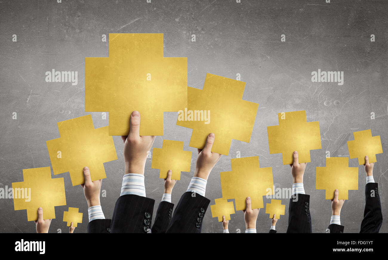 Many hands of business people holding plus signs Stock Photo - Alamy