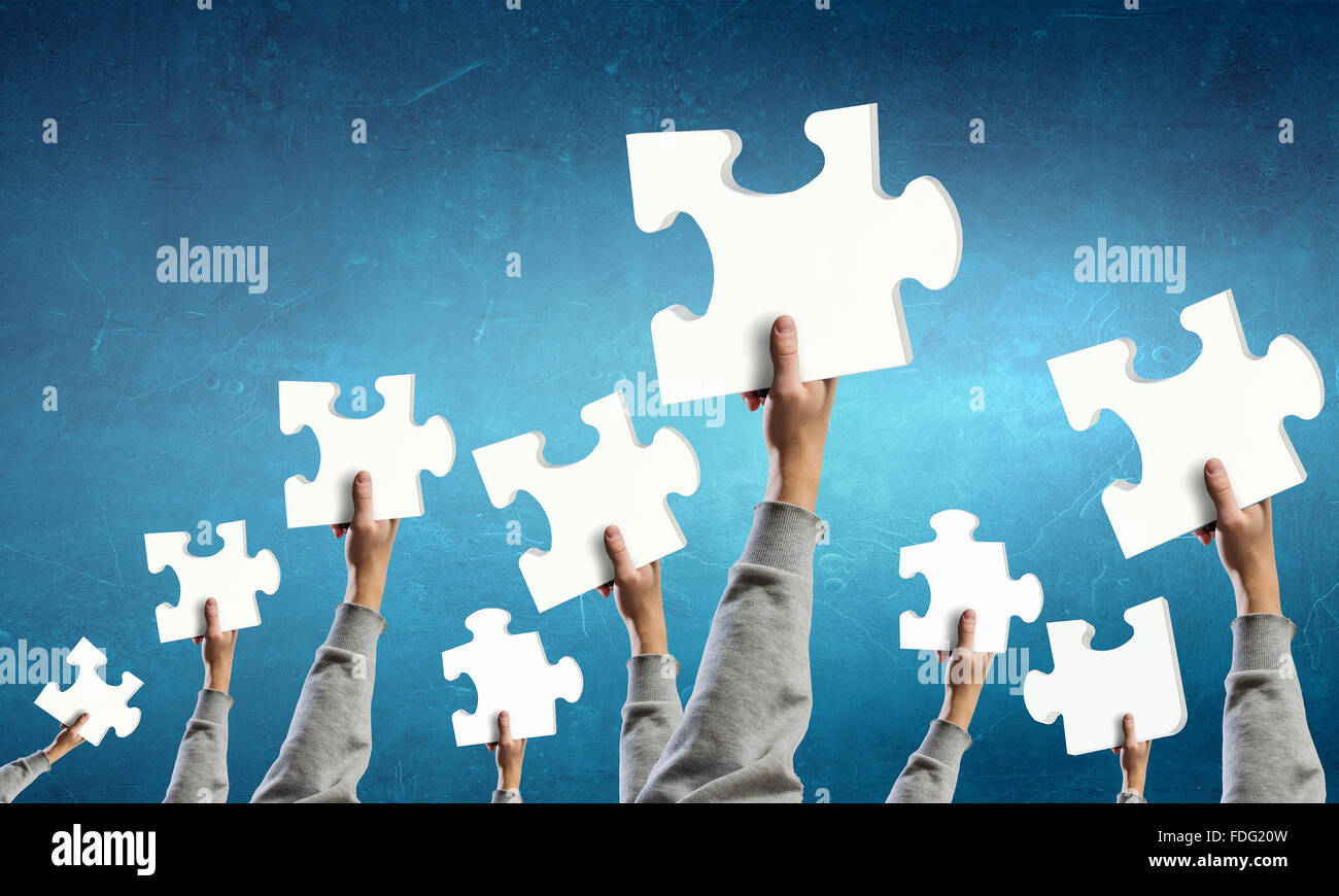 Human hands holding colorful jigsaw puzzle elements Stock Photo - Alamy
