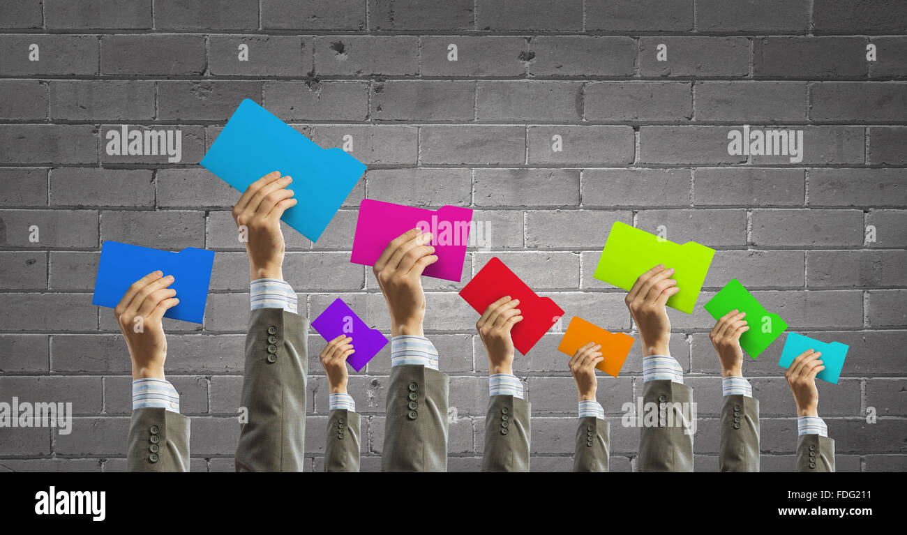 Group of business people holding folders in raised hands Stock Photo ...