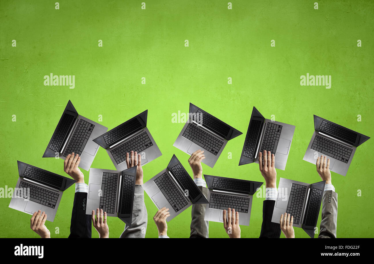 Many business people holding in hands laptops Stock Photo - Alamy