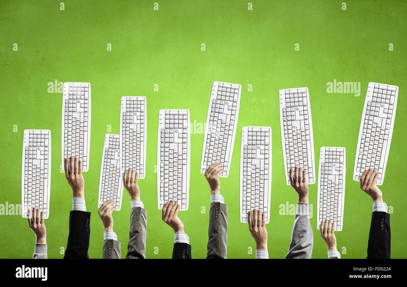 Group of business people holding keyboards in raised hands Stock Photo ...