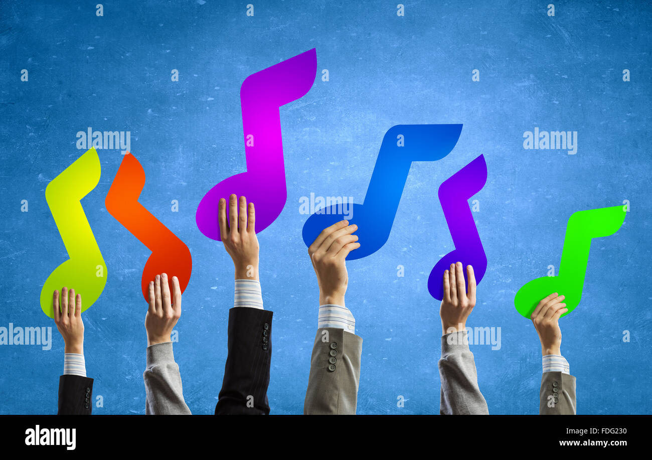 Group of people hands holding colorful music symbols Stock Photo - Alamy