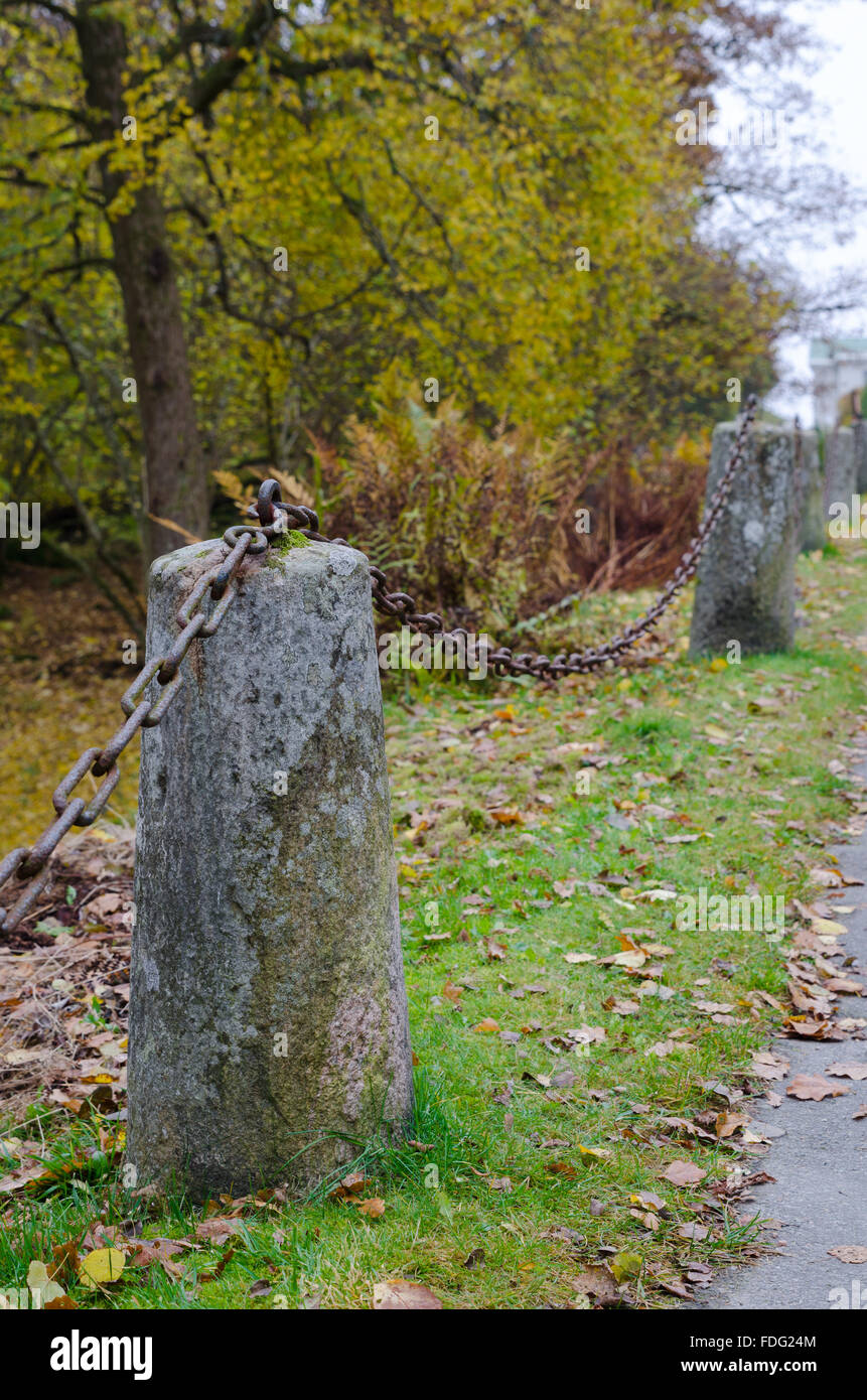 one rusty chain betwen two old stone Stock Photo - Alamy