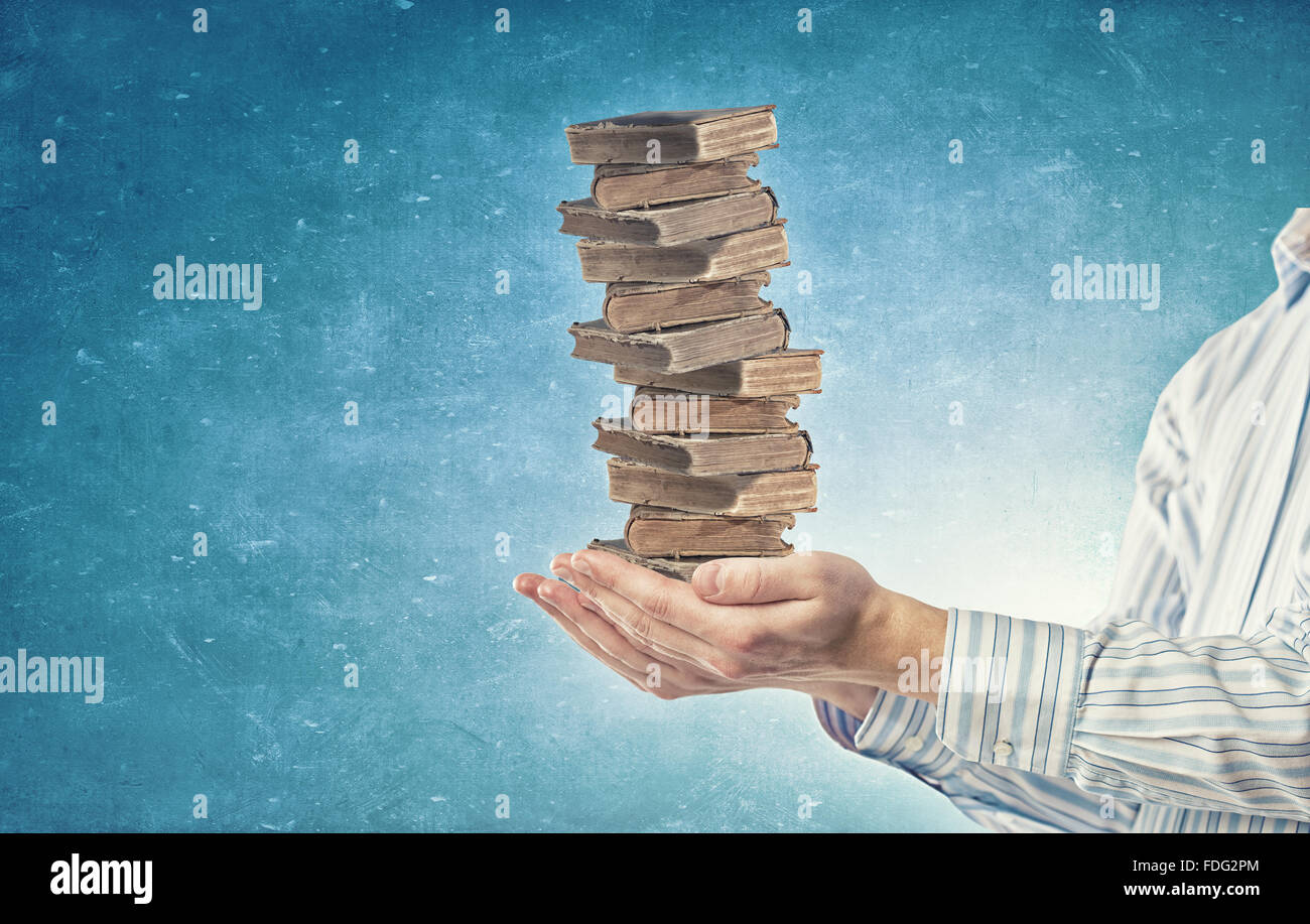 Male hands holding pile of old books Stock Photo - Alamy