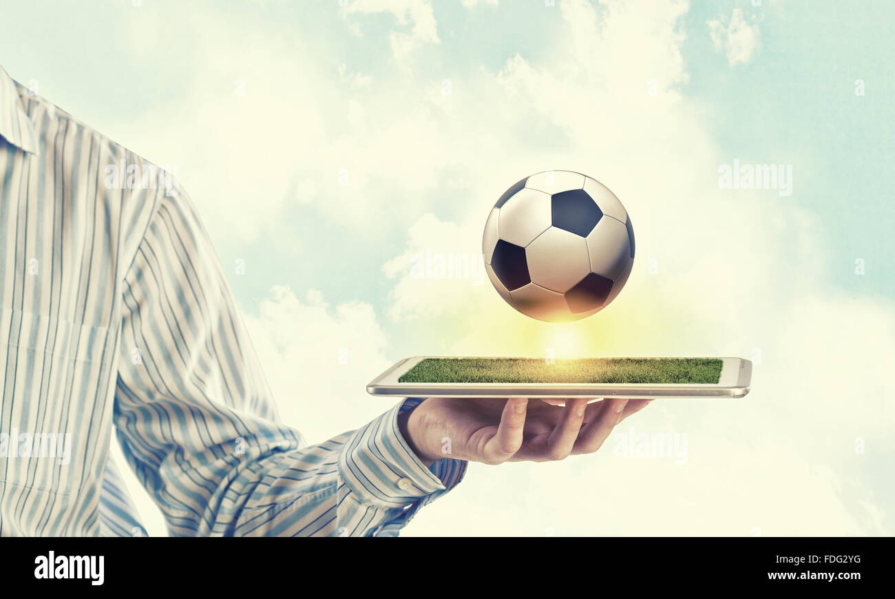Tablet pc in male hand and soccer ball on screen Stock Photo - Alamy