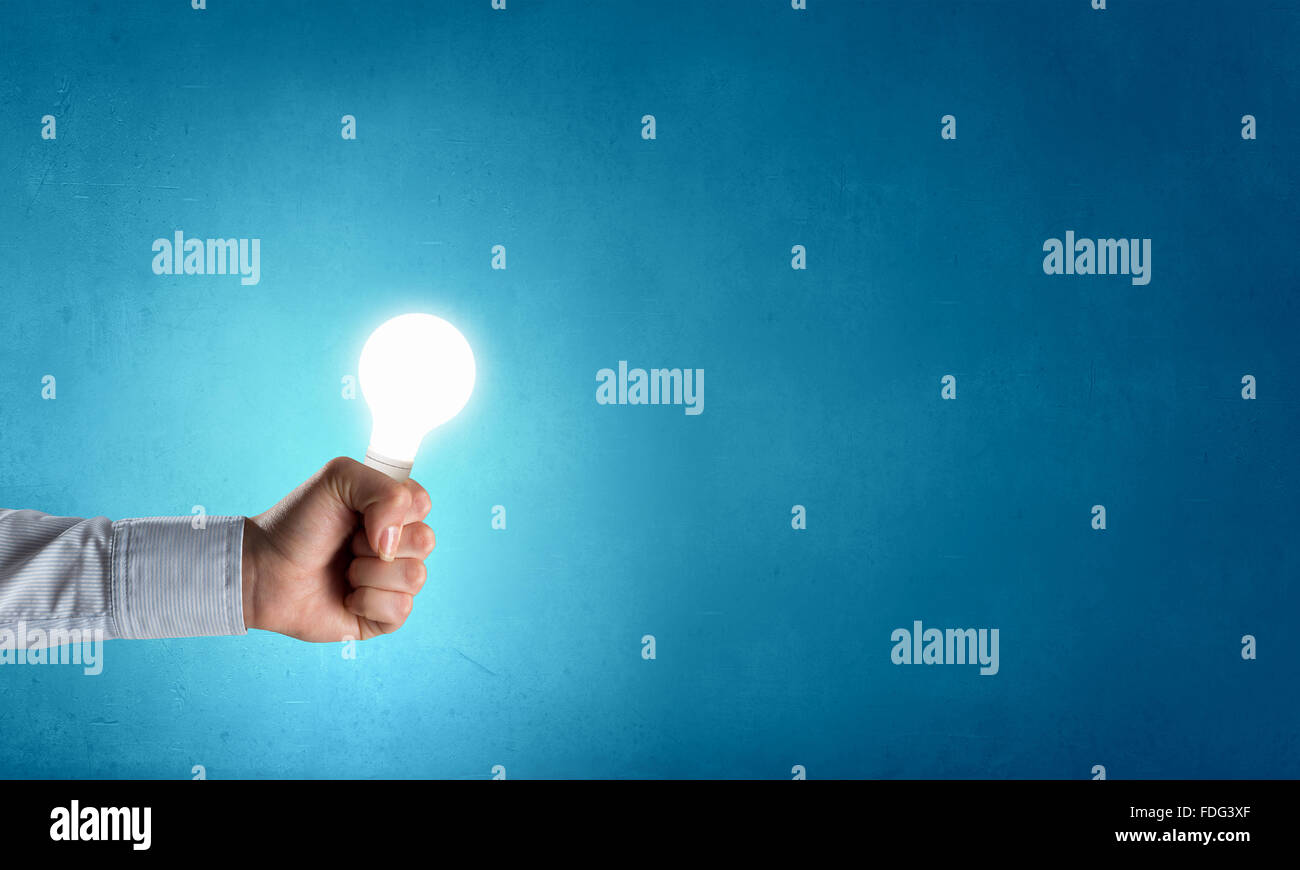 Close up of hand holding glowing light bulb Stock Photo - Alamy