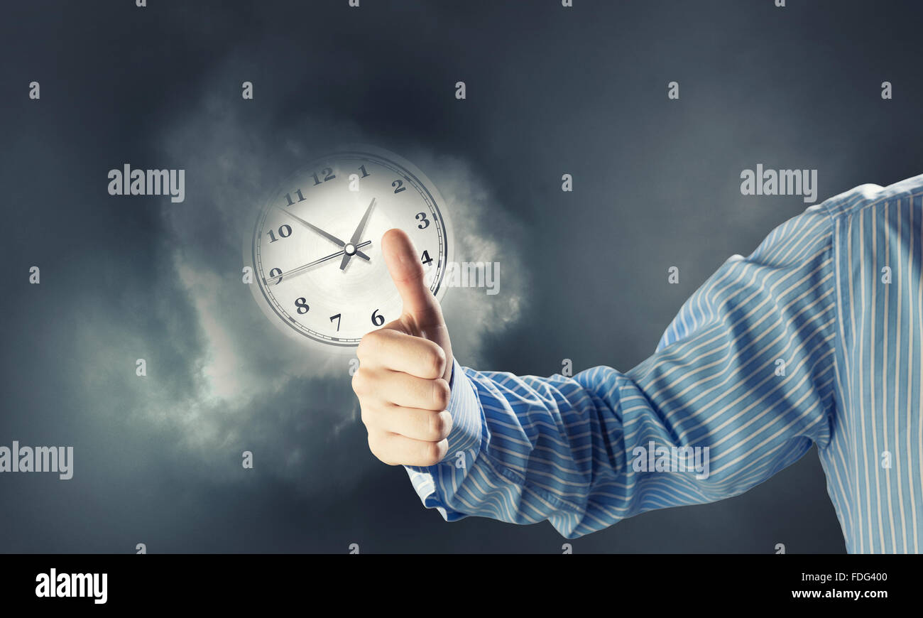 Hand of businessman showing thumb up to time concept Stock Photo - Alamy