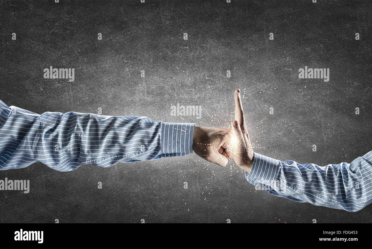 Hand with open palm stopping angry clenched fist Stock Photo - Alamy