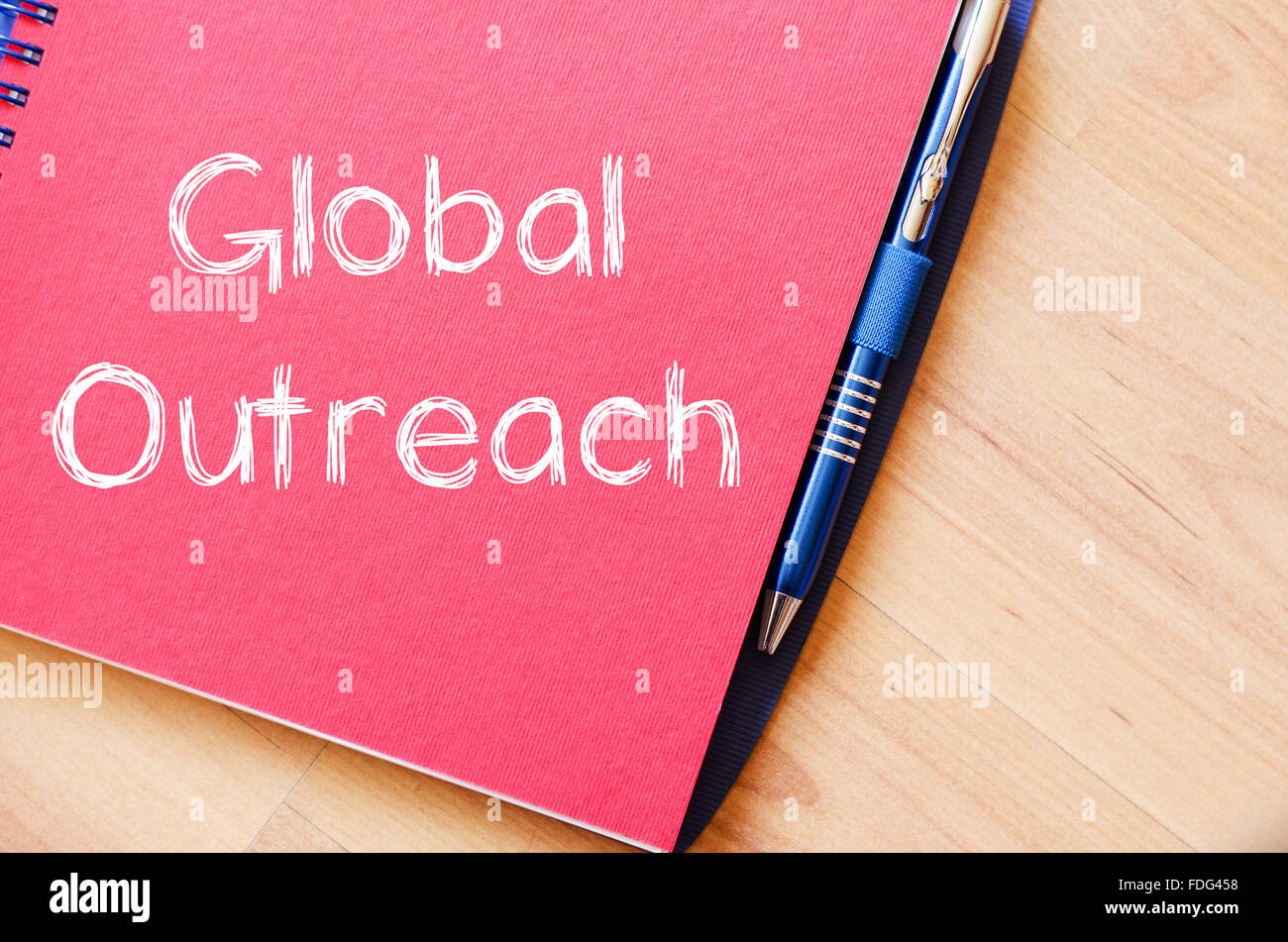 Global outreach text concept write on notebook with pen Stock Photo - Alamy