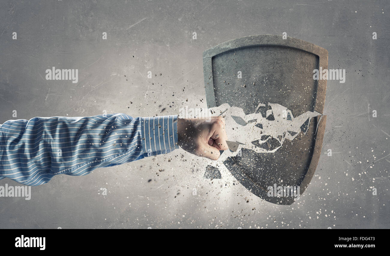 Conceptual image with hand breaking old stone shield Stock Photo - Alamy