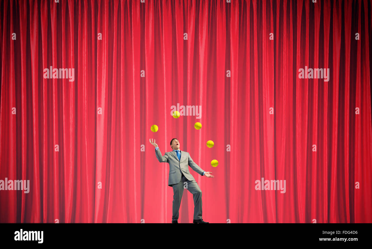 Young businessman in cap on stage juggling with balls Stock Photo - Alamy