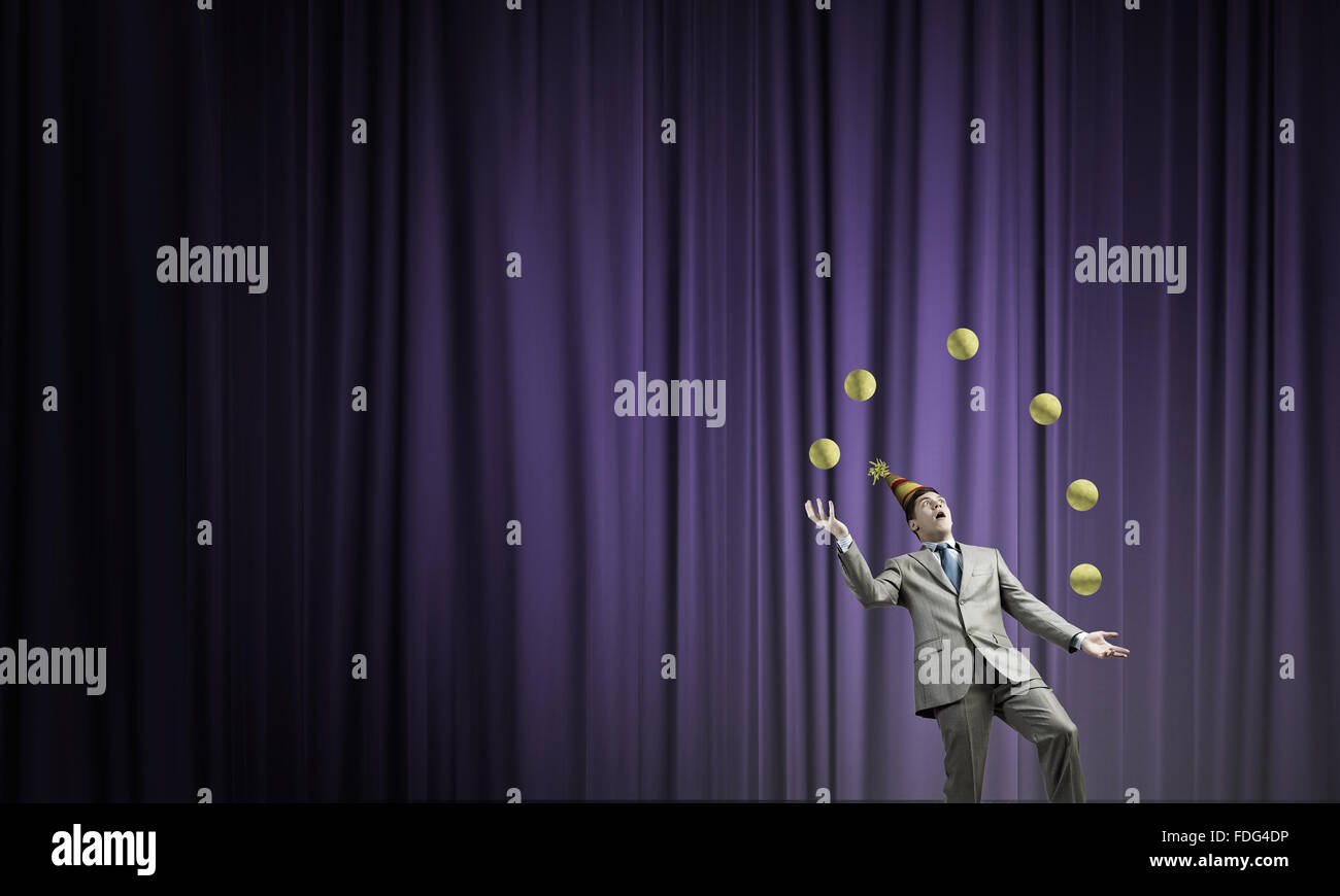 Young businessman in cap on stage juggling with balls Stock Photo - Alamy