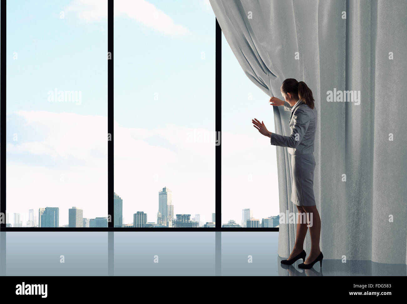 Businesswoman pulling curtain and cityscape behind it Stock Photo - Alamy