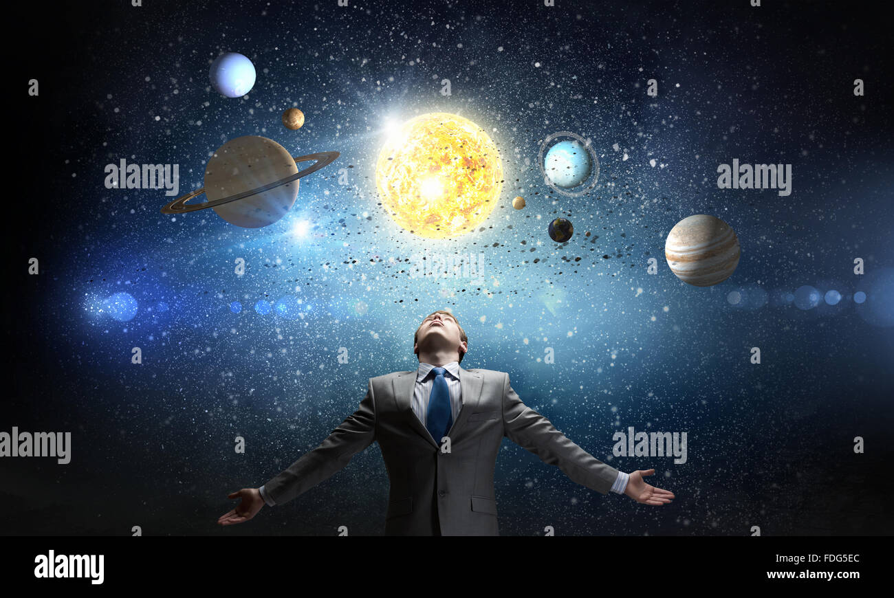 Young businessman looking at planets of sun system Stock Photo - Alamy