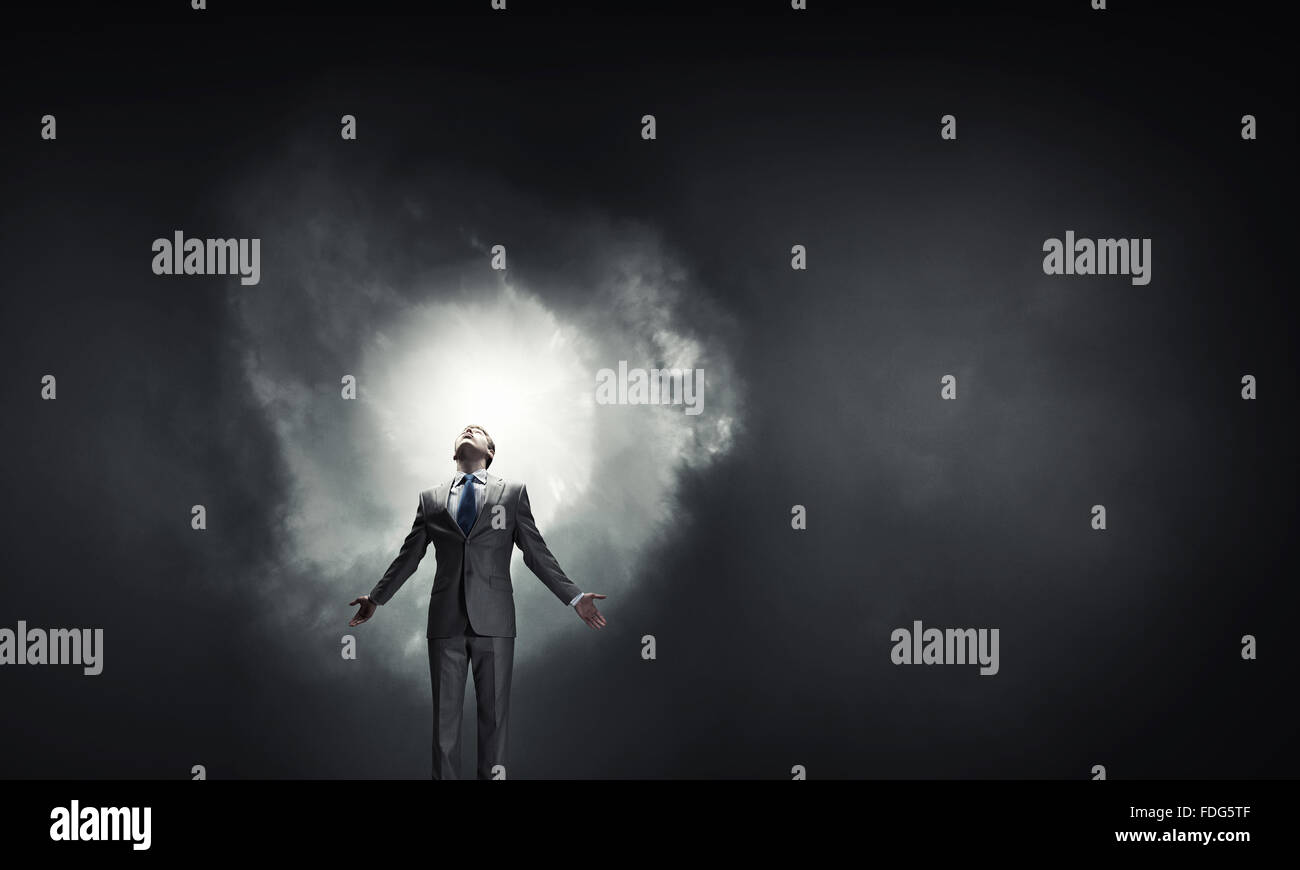 Businessman with hands spread apart on dark background Stock Photo - Alamy
