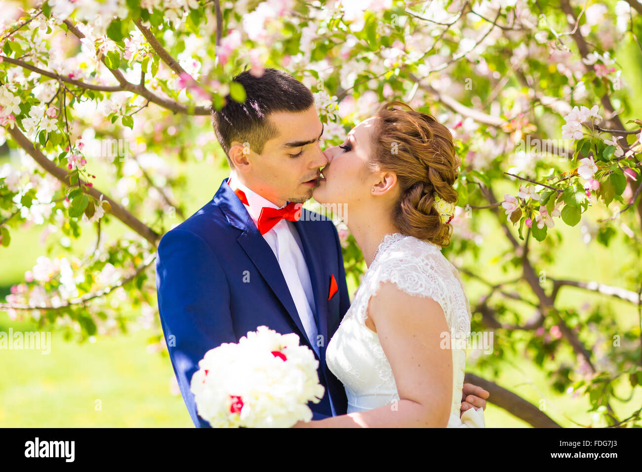 Kissing wedding couple in spring nature Stock Photo - Alamy