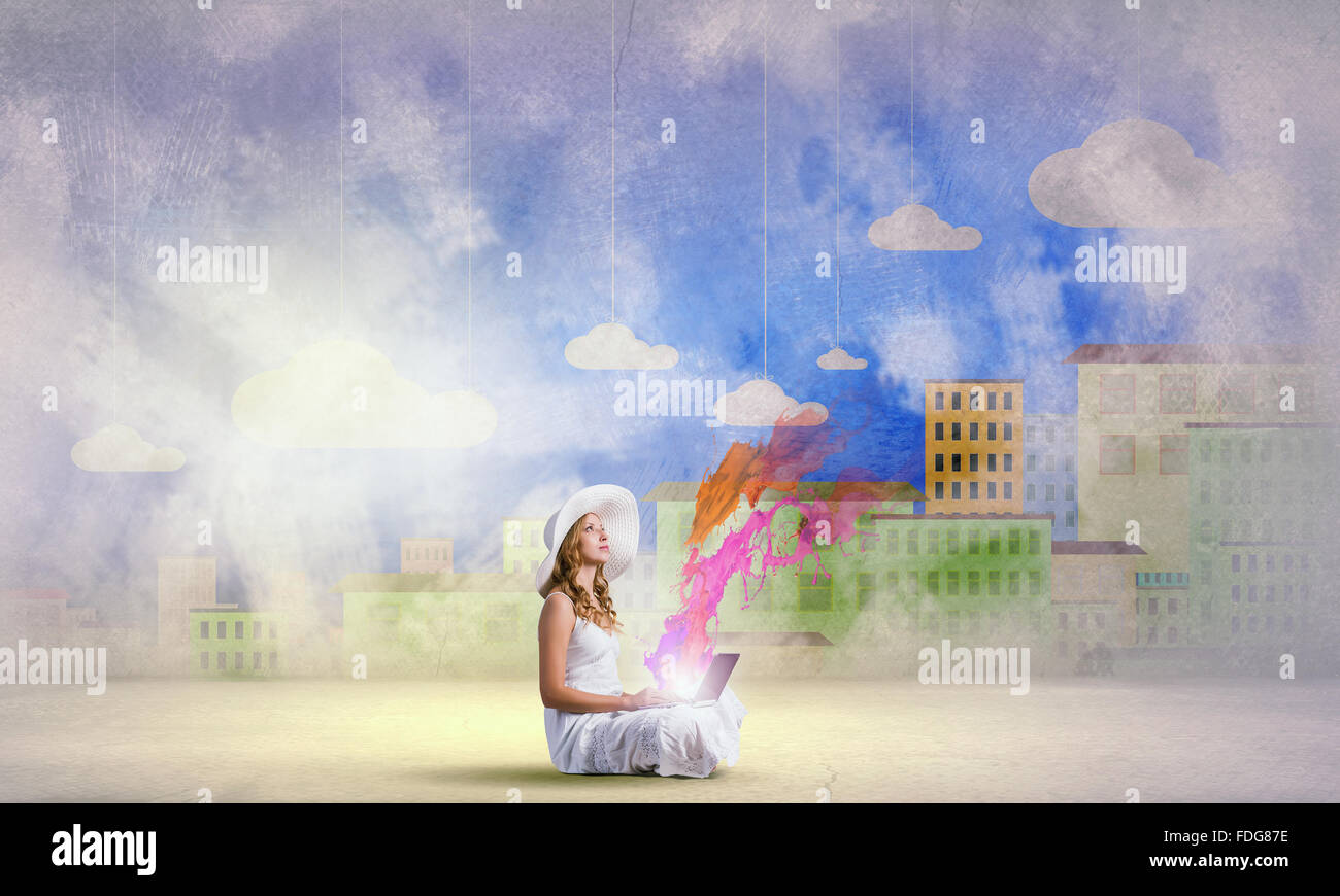 Young lady sitting on floor with laptop on knees Stock Photo - Alamy