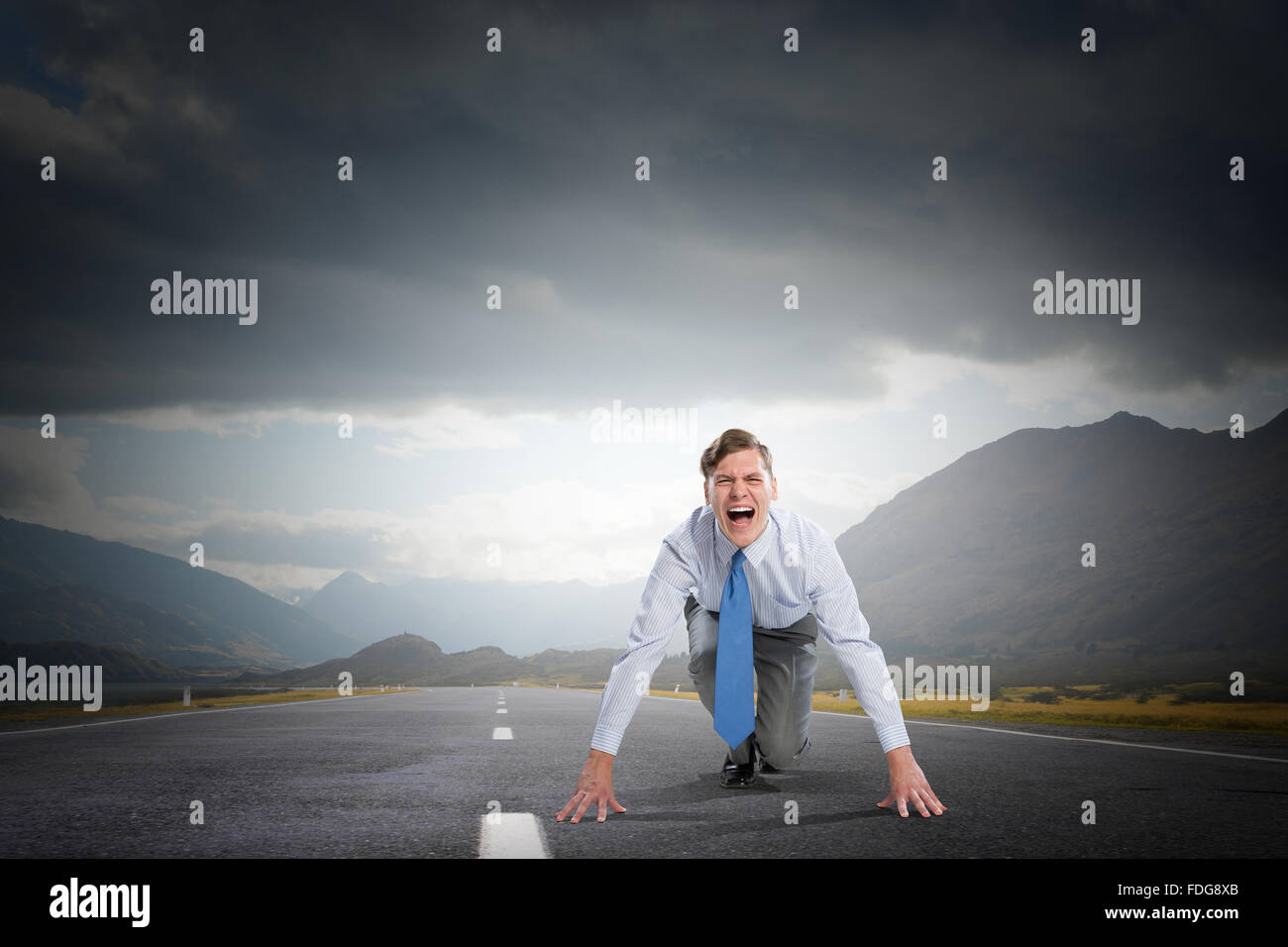 Young determined businessman in starting position ready to compete ...