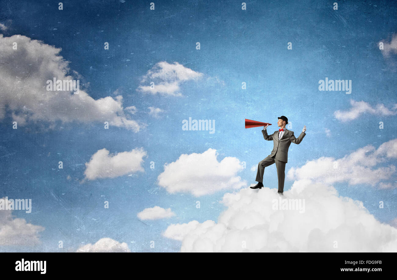 Young businessman on cloud screaming emotionally in paper trumpet Stock ...