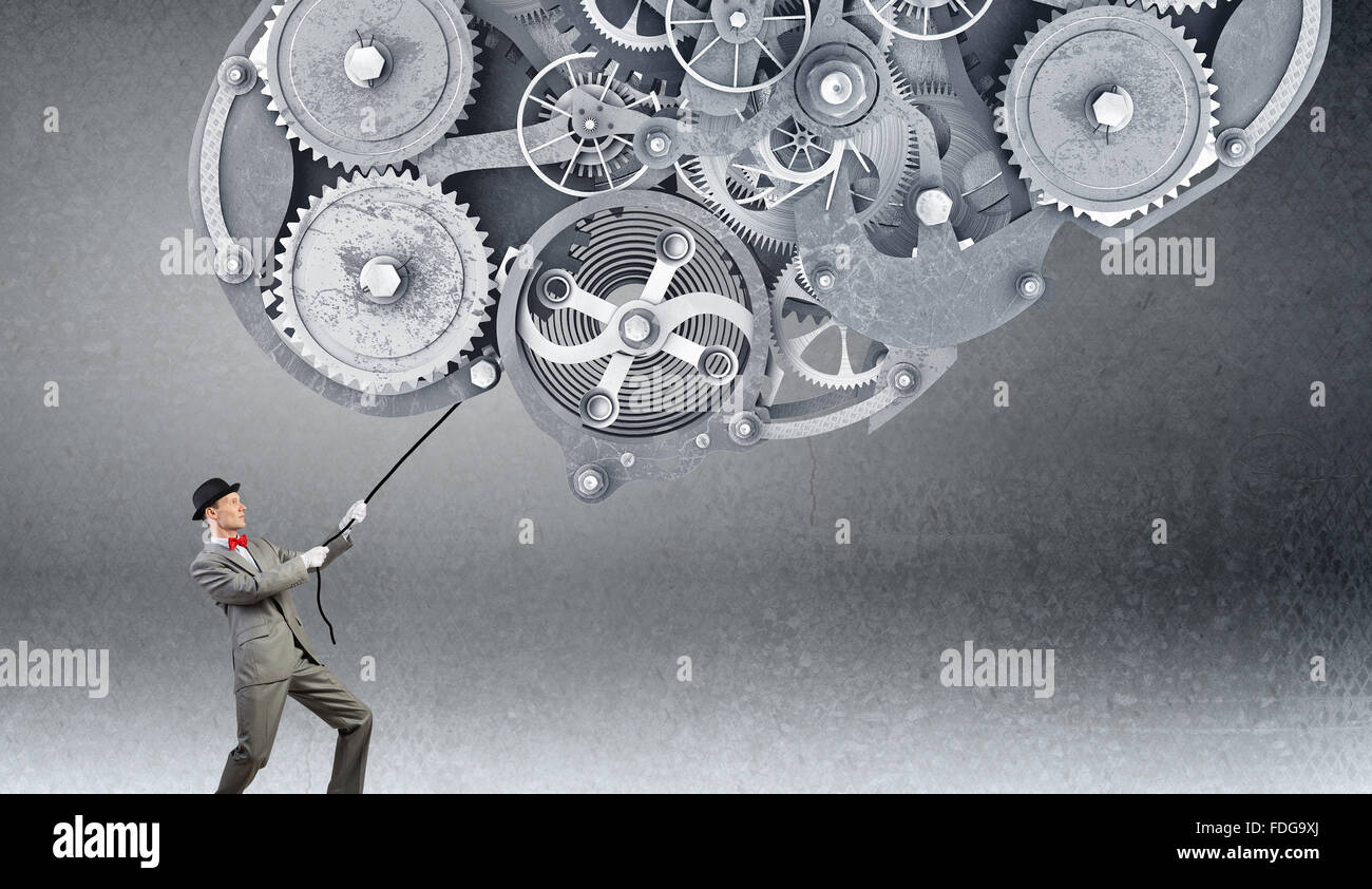 Young businessman pulling gears mechanism with rope Stock Photo - Alamy