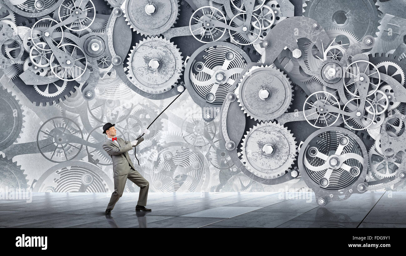 Young businessman pulling gears mechanism with rope Stock Photo - Alamy