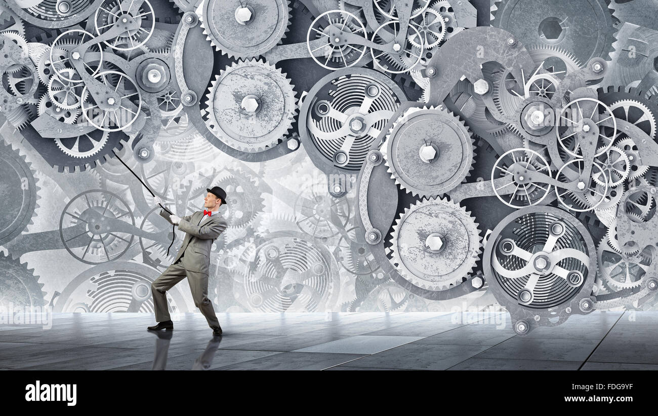 Young businessman pulling gears mechanism with rope Stock Photo - Alamy