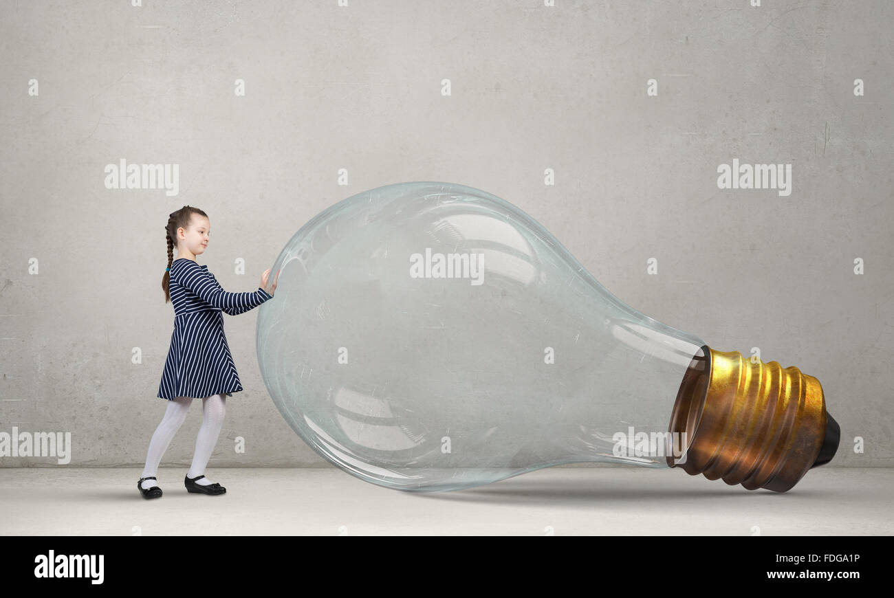 Cute kid girl pushing big glass light bulb Stock Photo - Alamy
