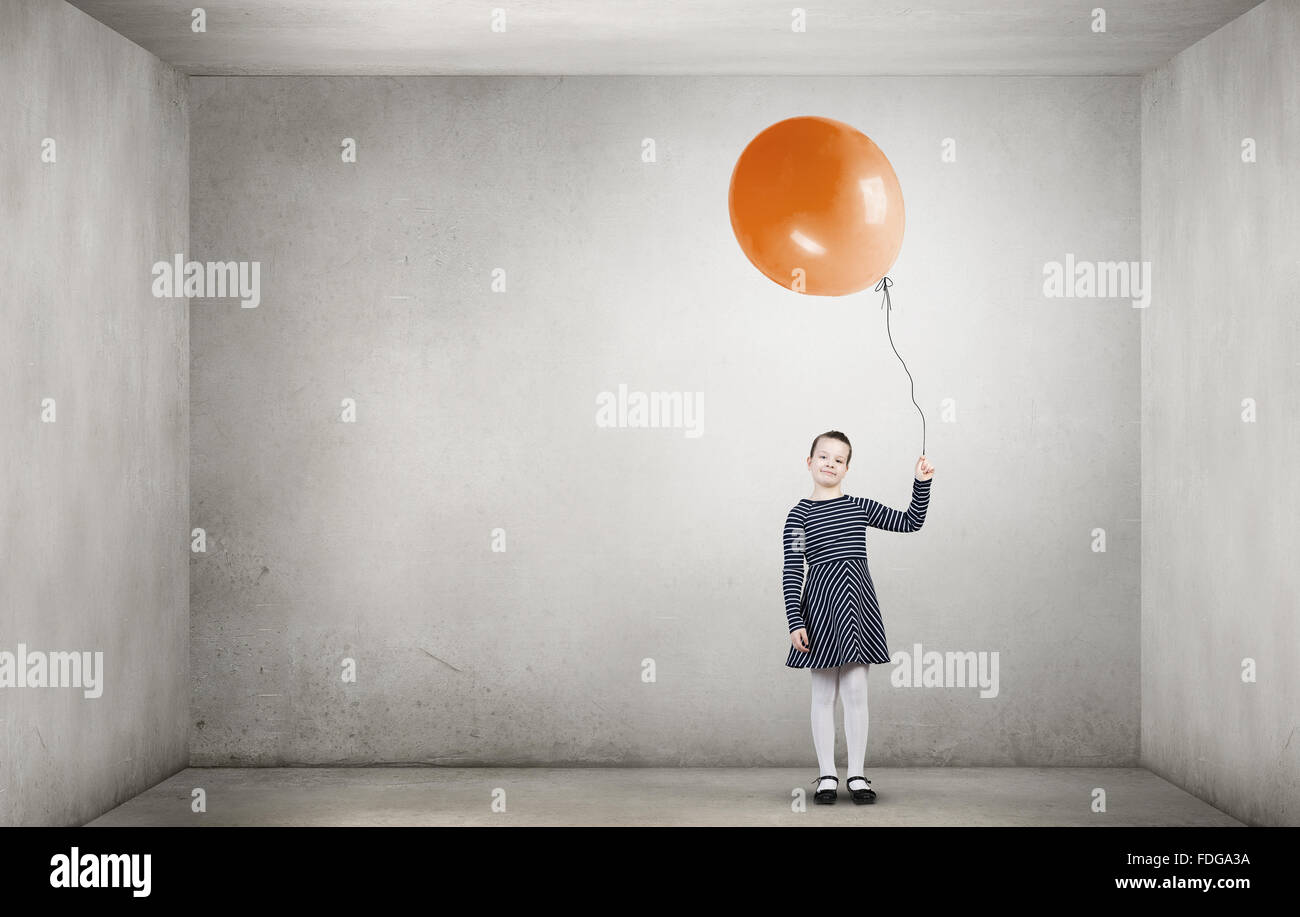 Cute girl in empty room with balloon Stock Photo - Alamy