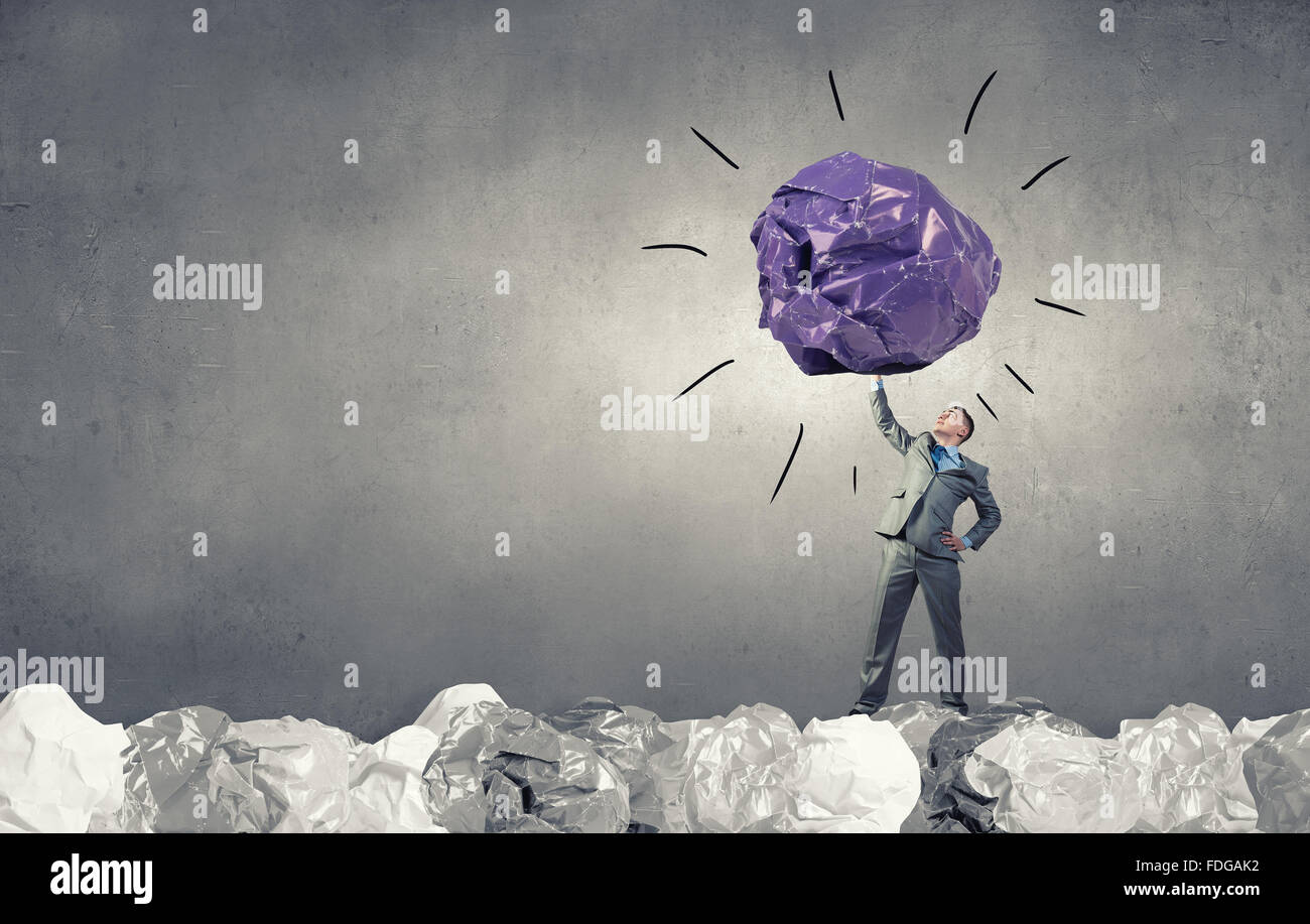 Businessman lifting in hand big crumpled ball of colorful paper as ...