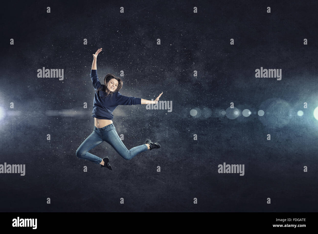 Young woman dancer jumping in spotlights on dark background Stock Photo ...