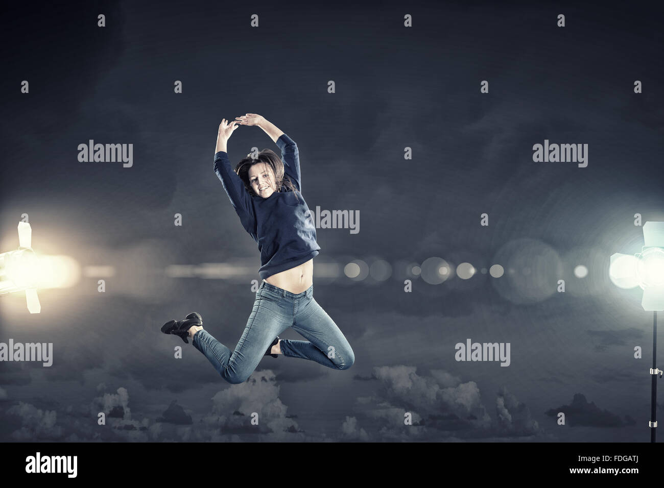 Young woman dancer jumping in spotlights on dark background Stock Photo ...