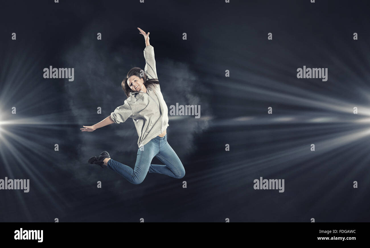 Young woman dancer jumping in spotlights on dark background Stock Photo ...