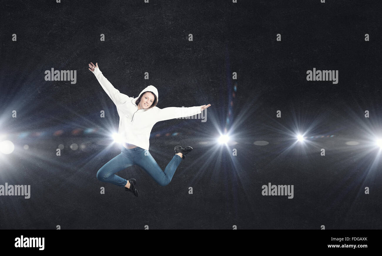 Young woman dancer jumping in spotlights on dark background Stock Photo ...