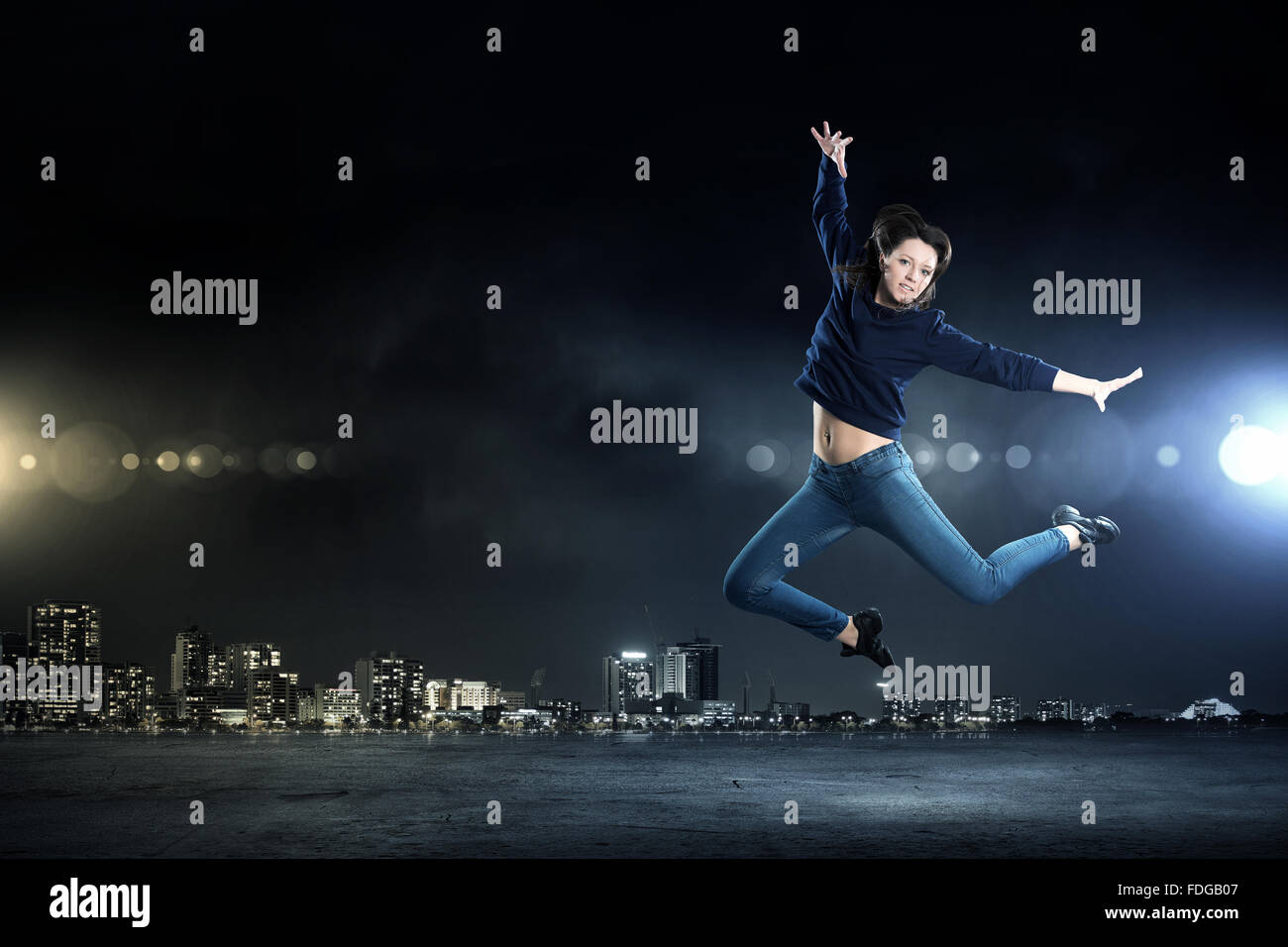 Young woman dancer jumping in spotlights on dark background Stock Photo ...
