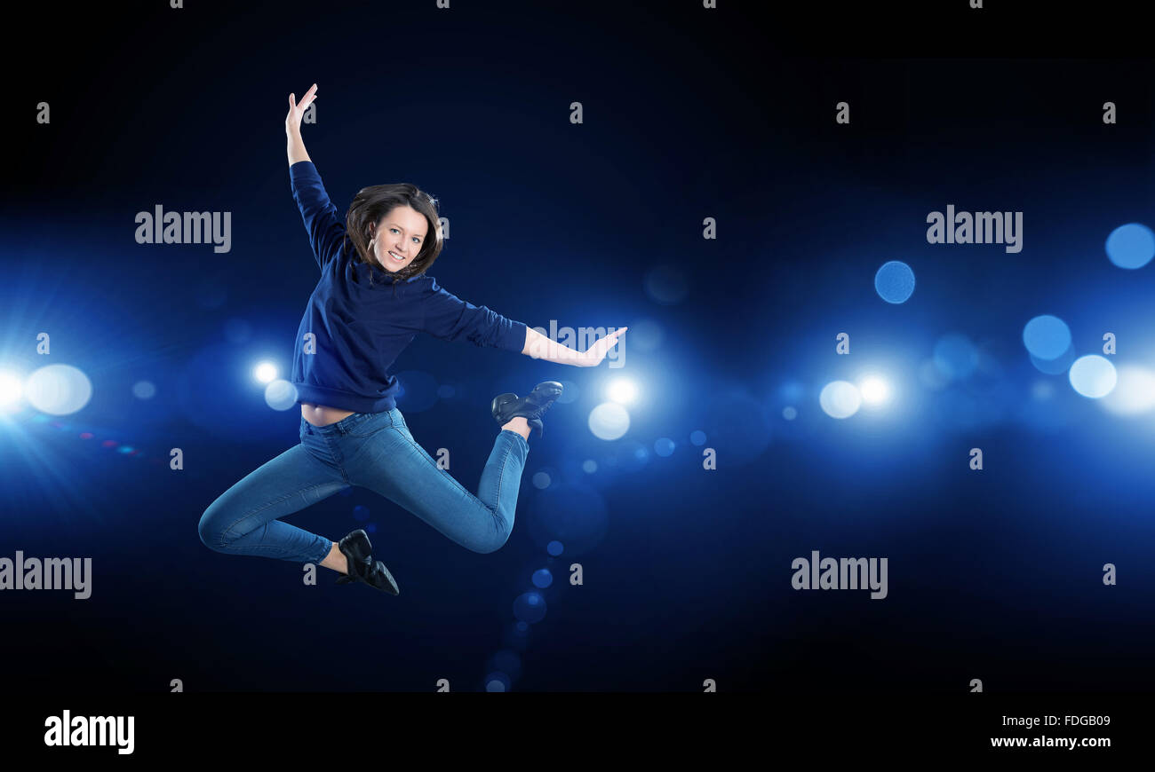Young woman dancer jumping in spotlights on dark background Stock Photo ...