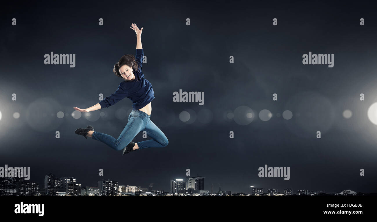 Young woman dancer jumping in spotlights on dark background Stock Photo ...
