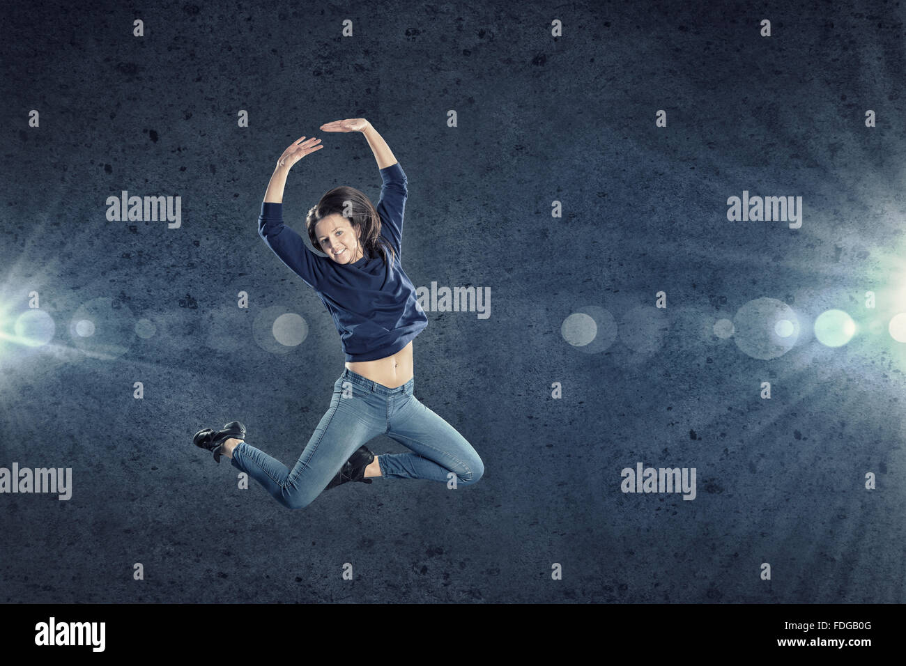 Young woman dancer jumping in spotlights on dark background Stock Photo ...