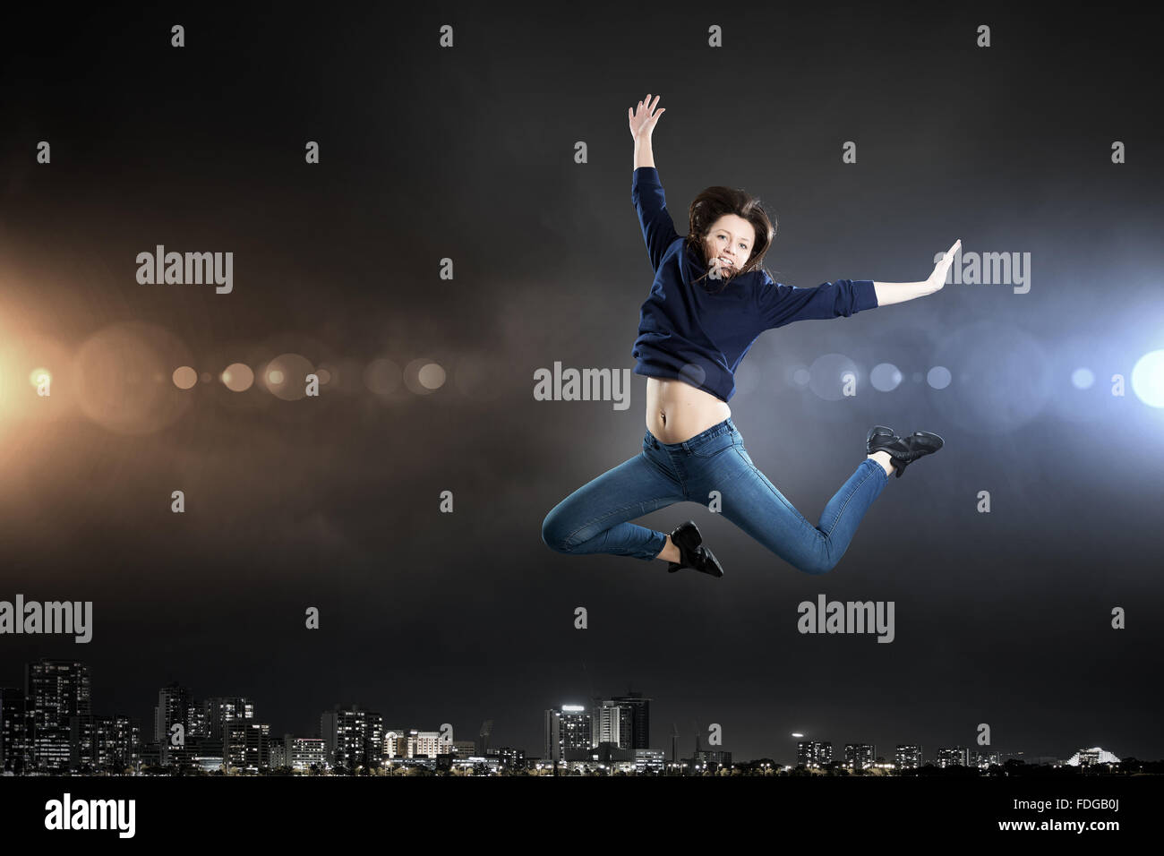 Young woman dancer jumping in spotlights on dark background Stock Photo ...