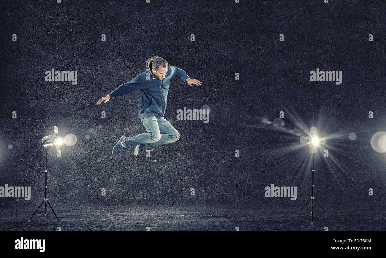 Modern style male dancer jumping in lights of spotlight Stock Photo - Alamy