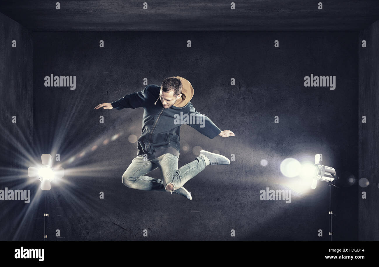 Modern style male dancer jumping in lights of spotlight Stock Photo - Alamy