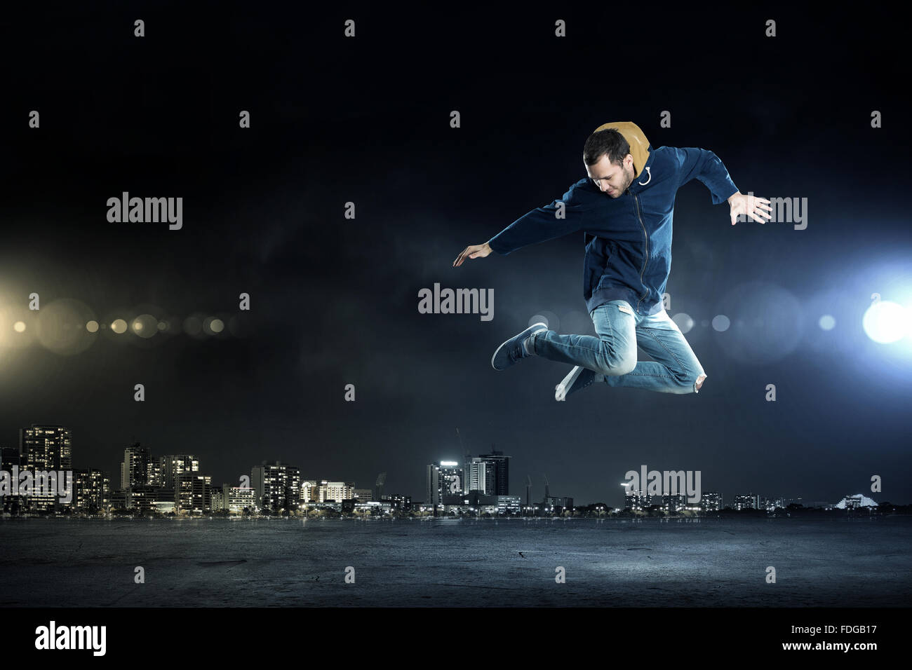 Modern style male dancer jumping in lights of spotlight Stock Photo - Alamy